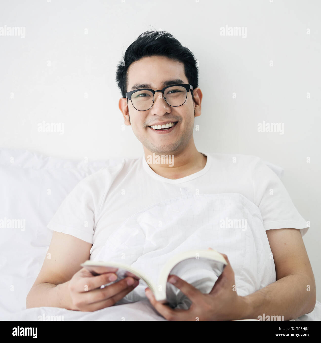 Asian man reading a book on bed in weekend, lifestyle concept Stock ...