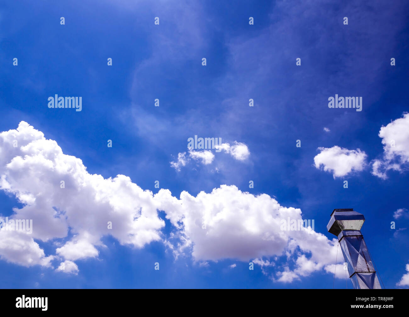 Shiny steel smokestack and cloud in blue sky Stock Photo - Alamy