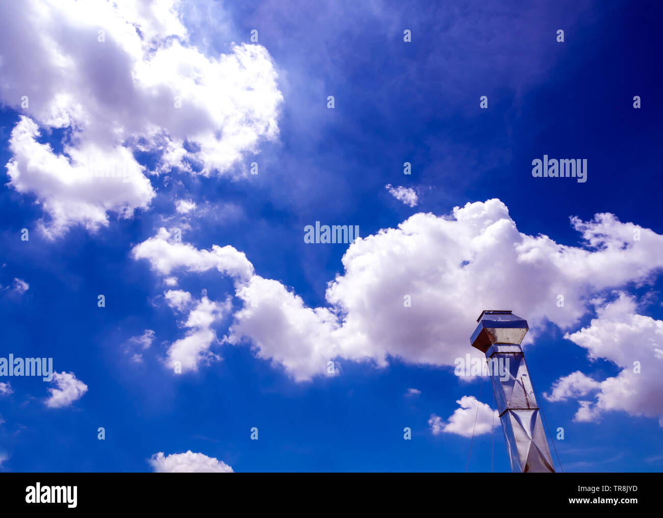 Shiny steel smokestack and cloud in blue sky Stock Photo - Alamy