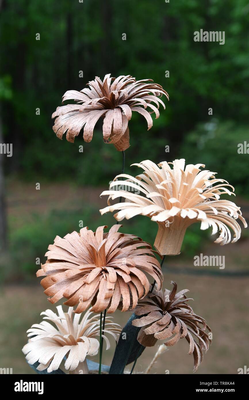 Close-up view of a group of wood carved flowers of various colors with ...
