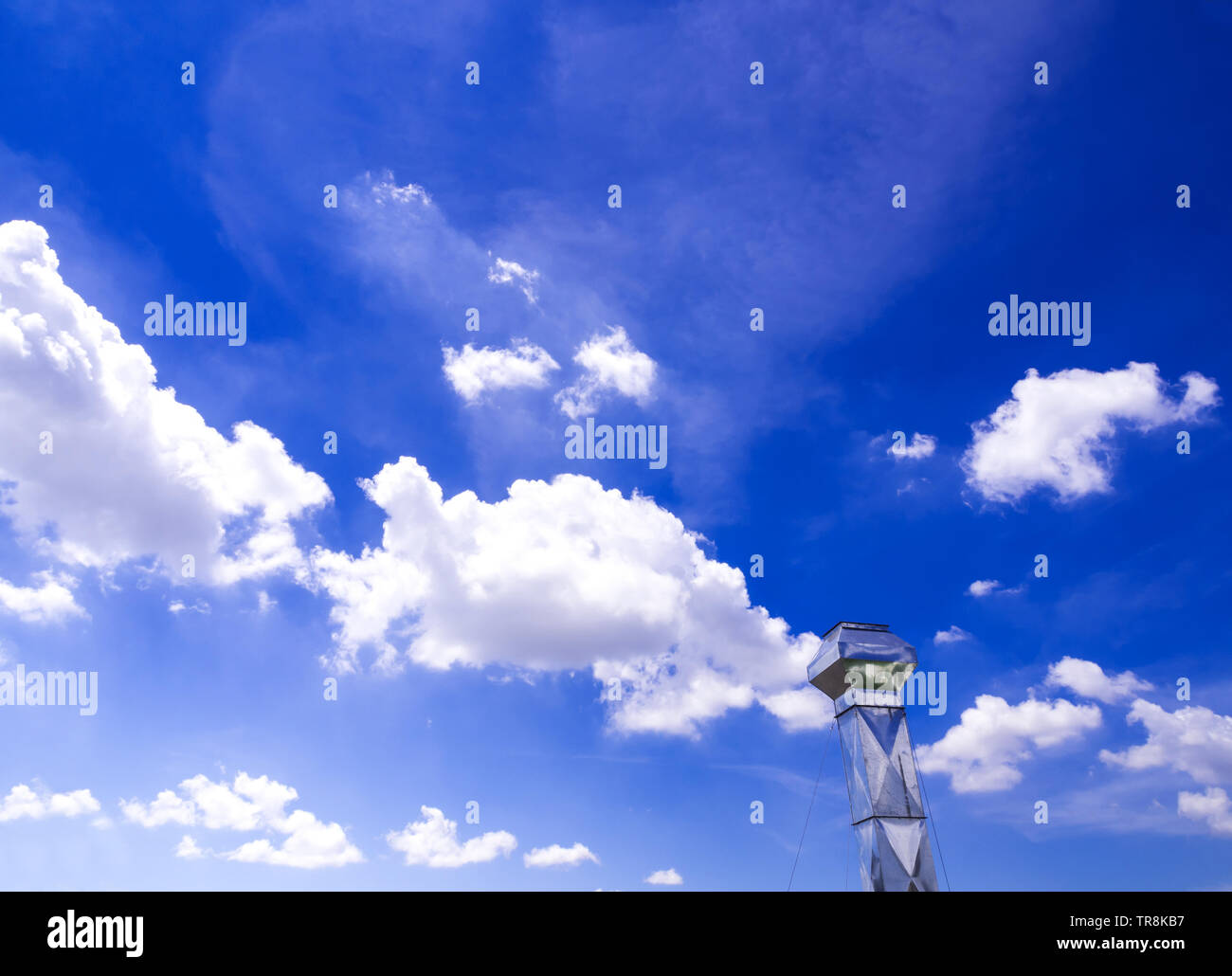 Shiny steel smokestack and cloud in blue sky Stock Photo - Alamy