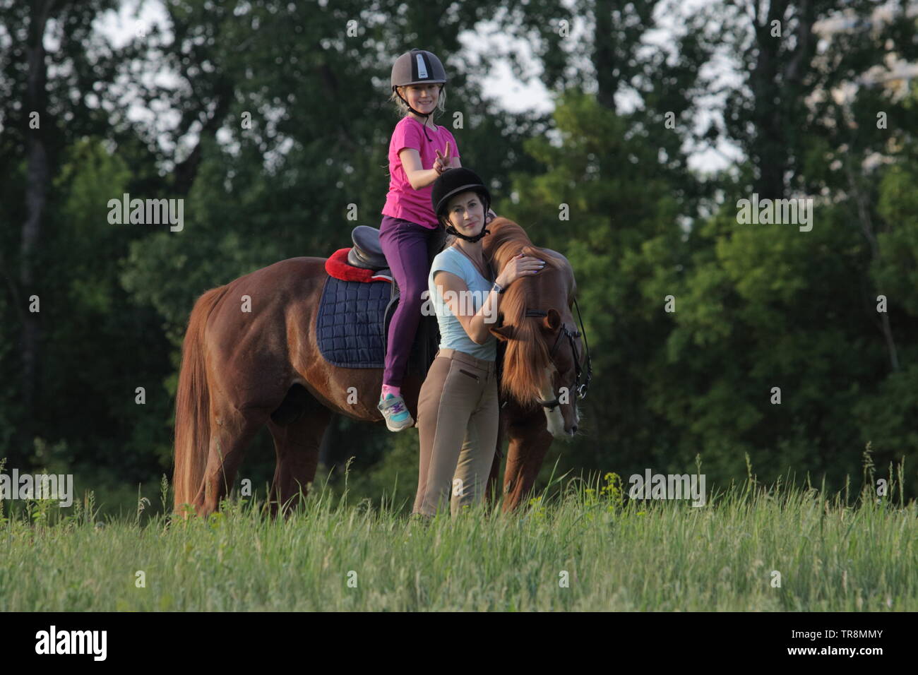 Mother walking alongside her daughter on horseback Stock Photo - Alamy