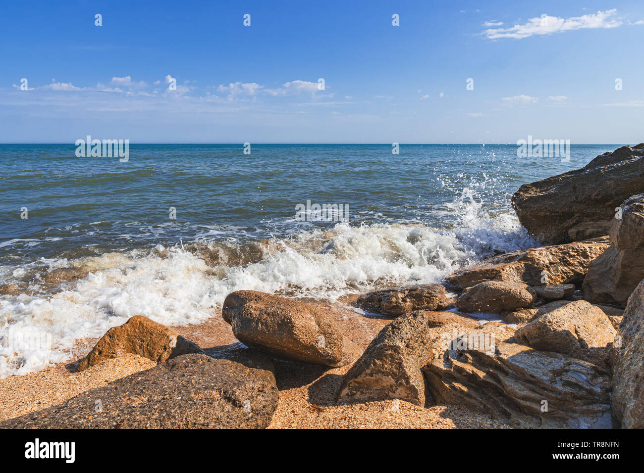 Summer beach with rocks and splashing waves Stock Photo - Alamy