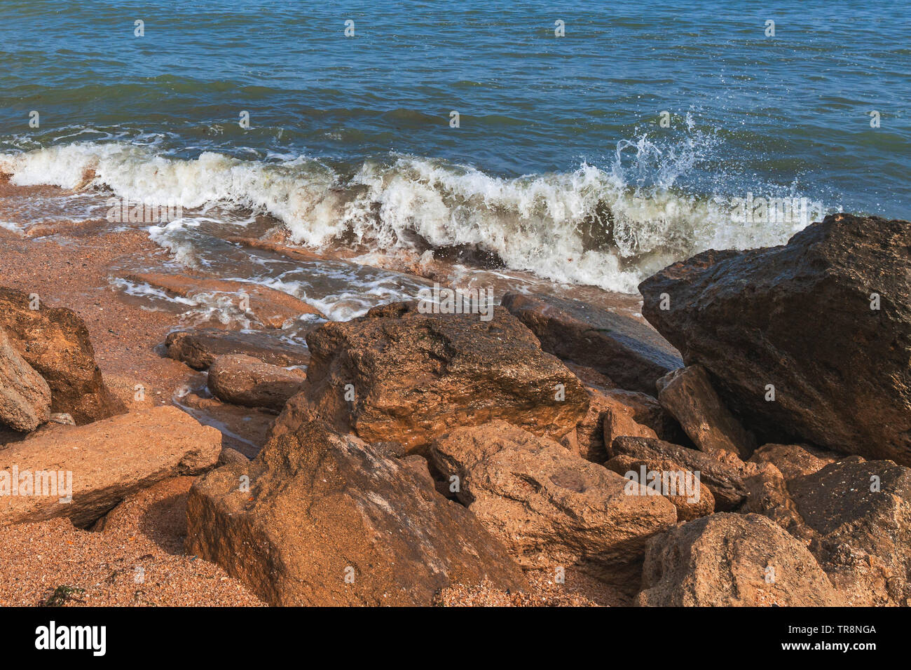 Summer beach with rocks and splashing waves Stock Photo - Alamy