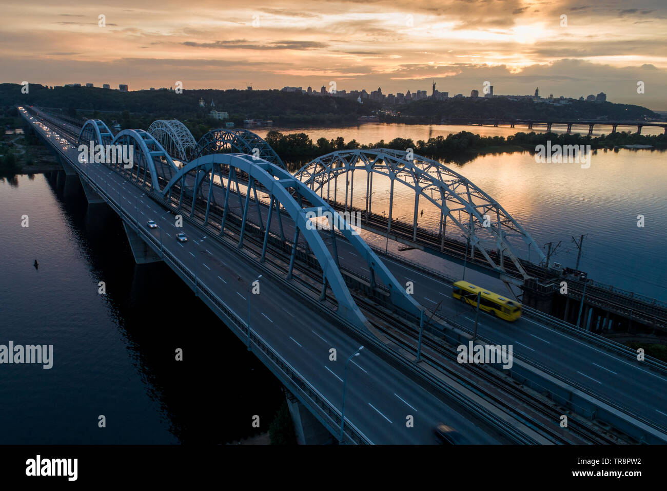 Sunset aerial view on a Darnitsky Bridge, big vehicle and railroad ...