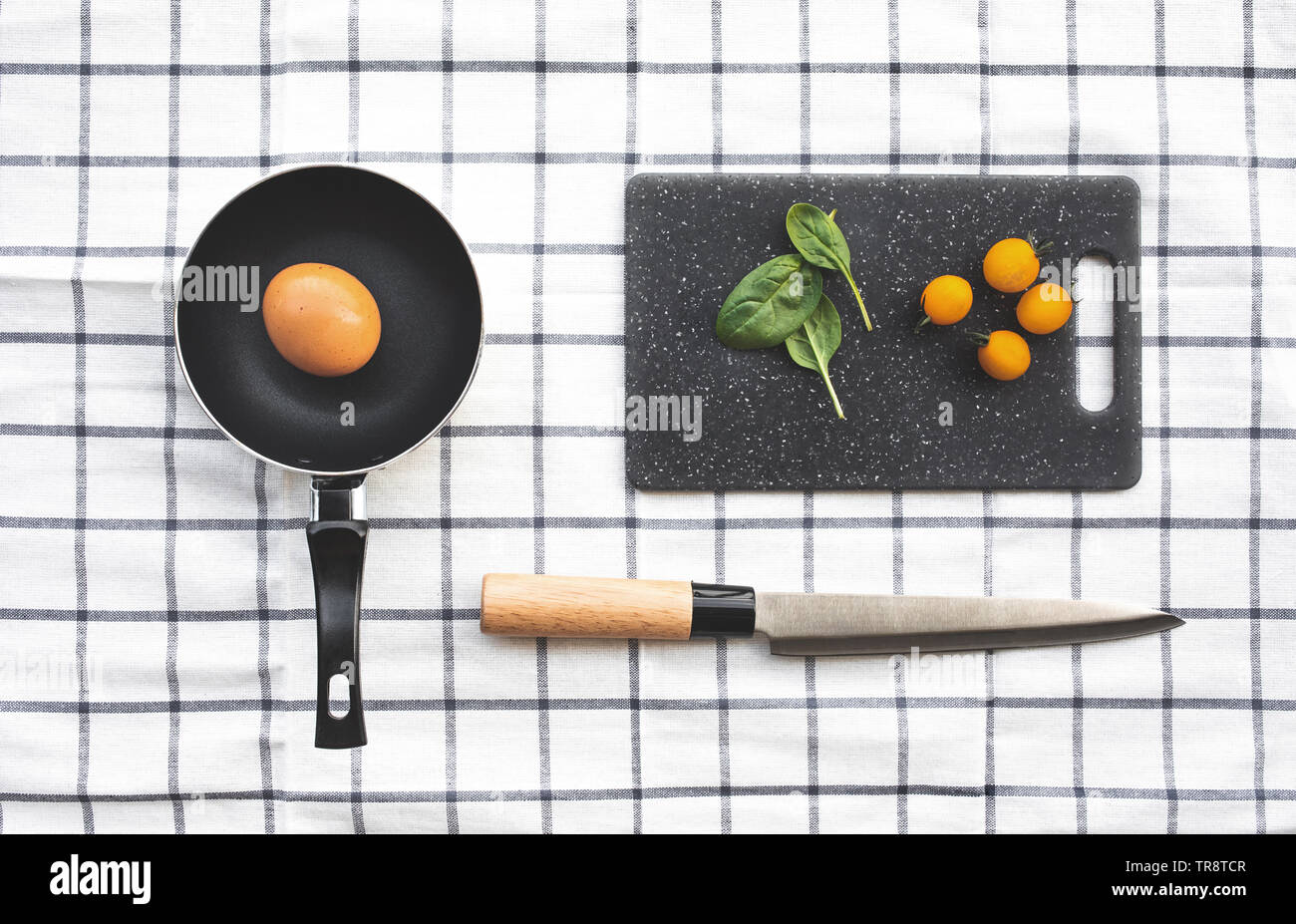 Top view of cooking set ingredients on checkered cloth table background ...