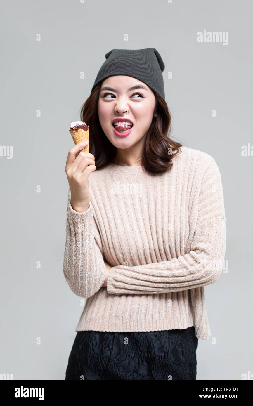 Young woman eating ice cream cone Stock Photo - Alamy