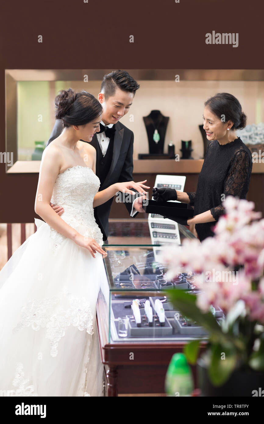 Happy bride and groom shopping in jewelry store Stock Photo - Alamy