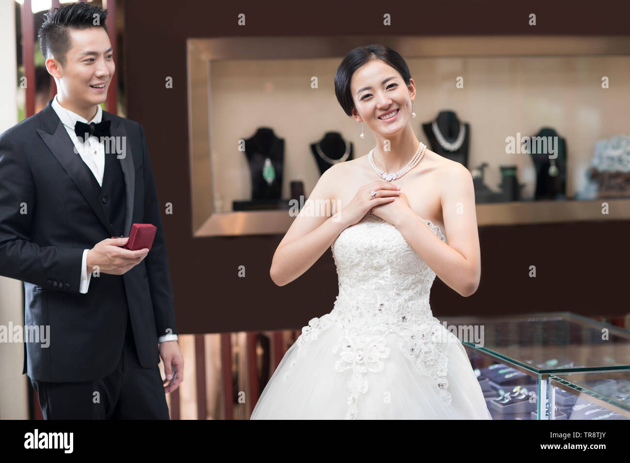Happy bride and groom shopping in jewelry store Stock Photo - Alamy