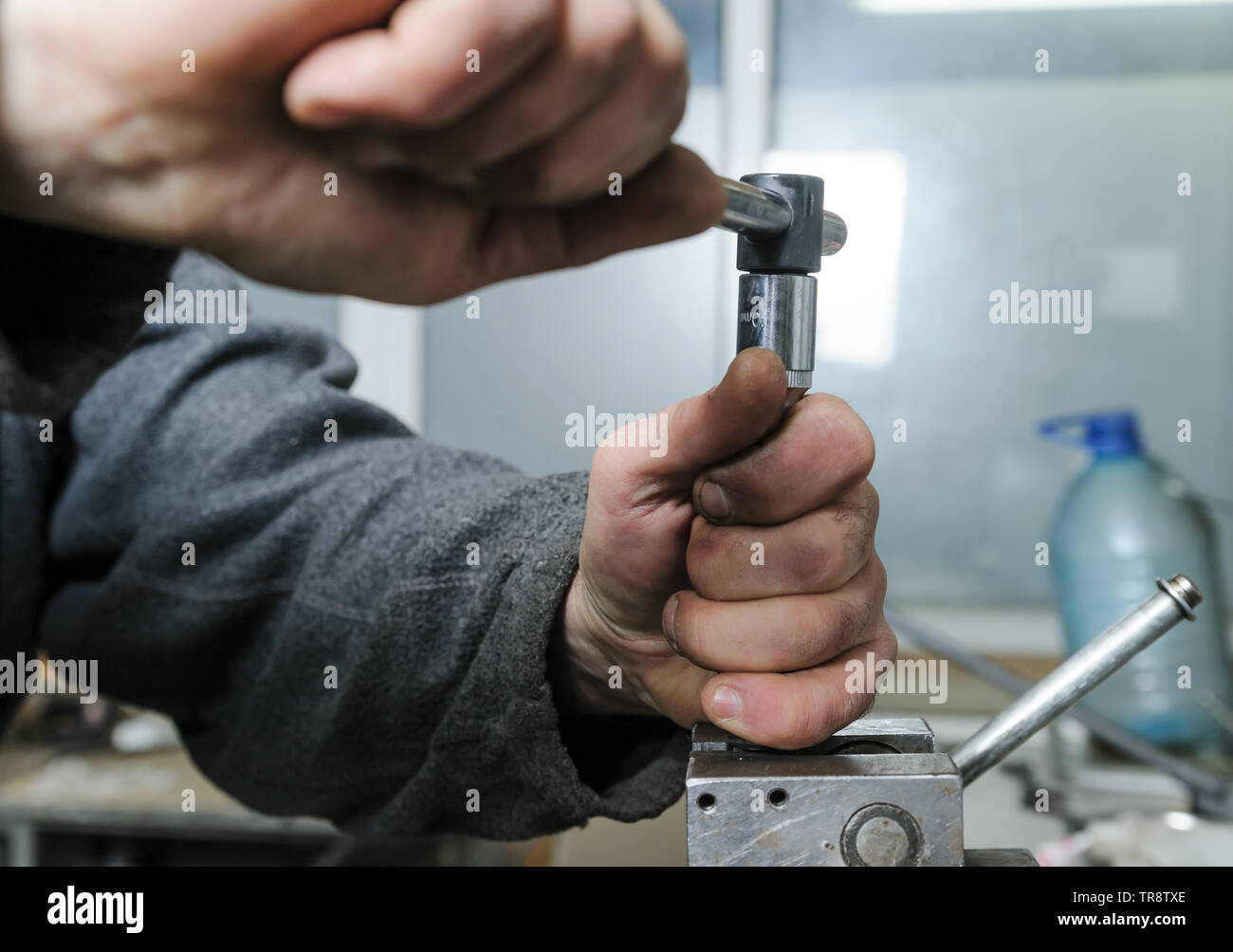 Mechanics repairing a diesel injector. Man's hand holding a wrench and ...