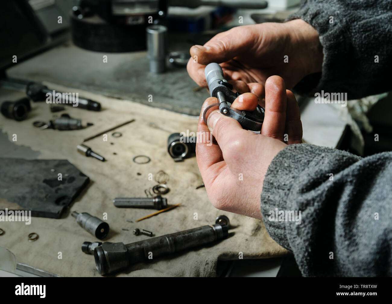 Mechanics repairing a diesel injector. Workers hands is holding ...