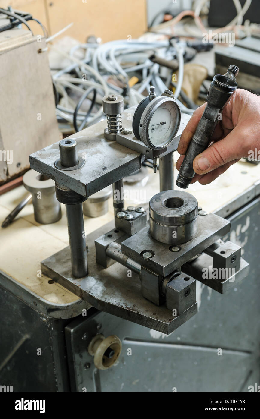Mechanics a repairing a diesel injector. Worker's hands holds the ...