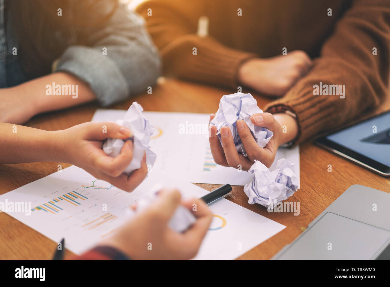 A businessman screwed up papers by hand with laptop, tablet and paper ...
