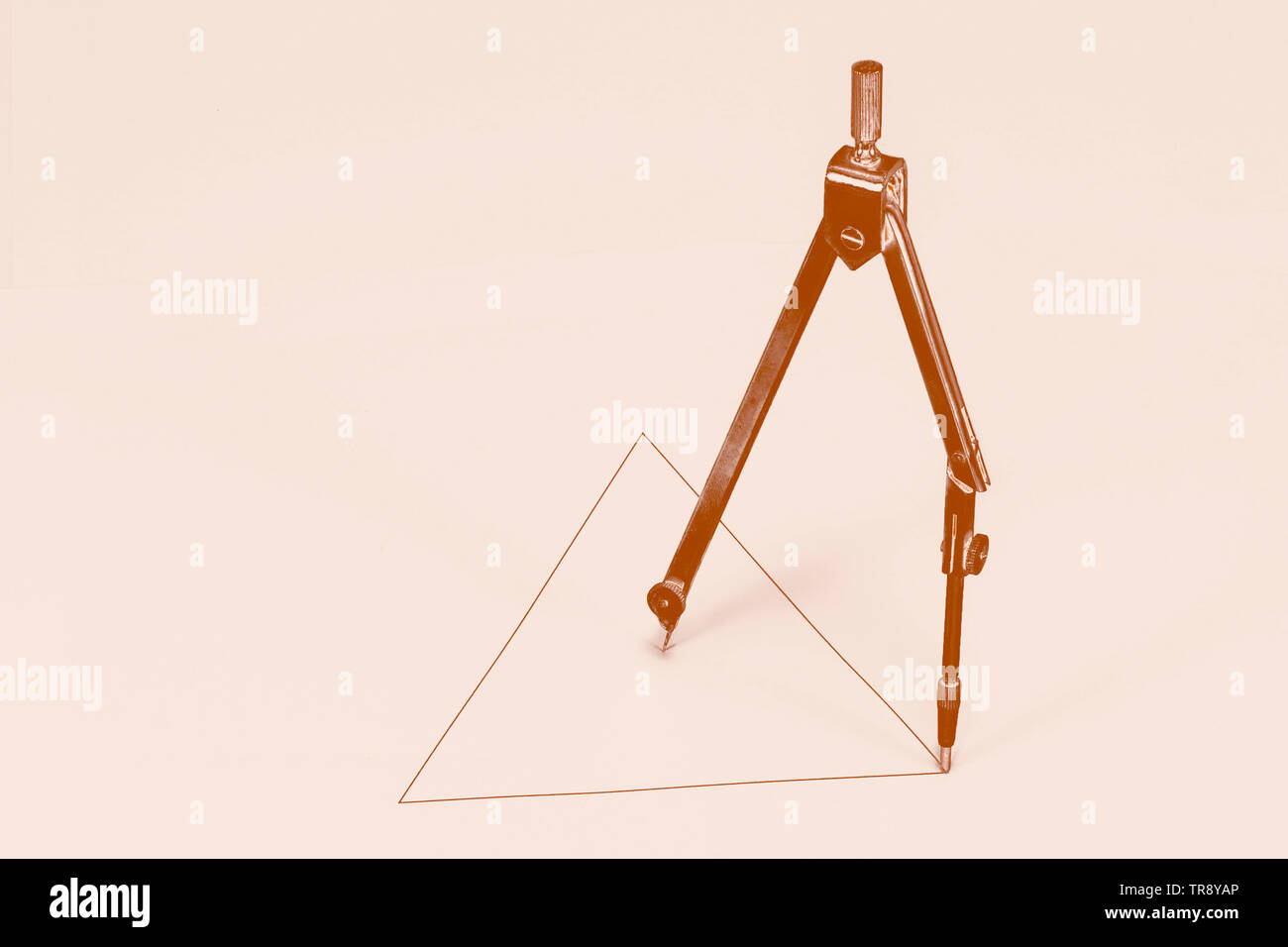 Creating the impossible. A compass drawing a triangle Stock Photo - Alamy