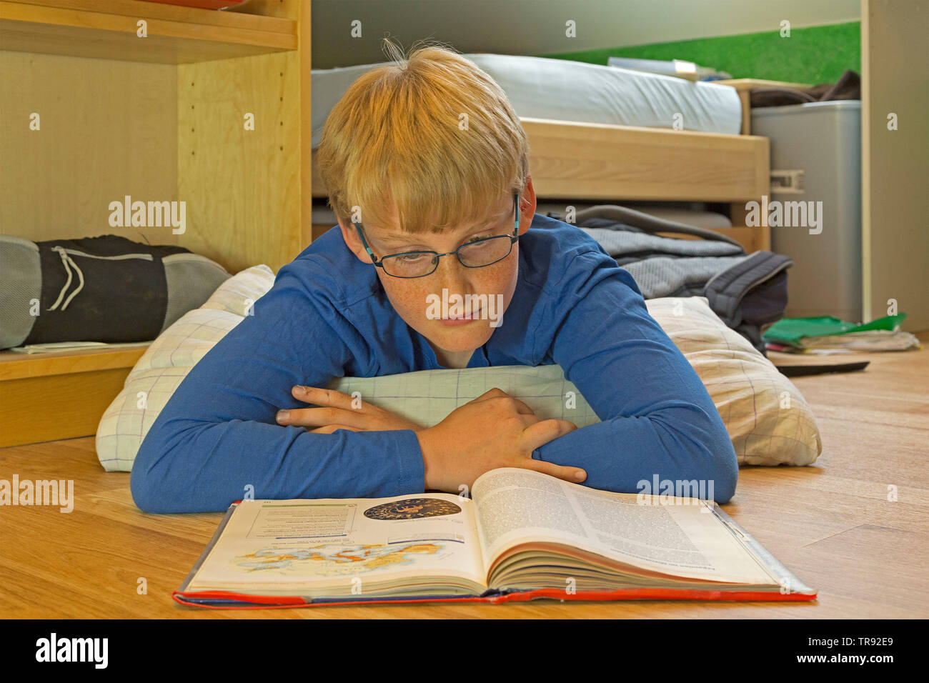 boy lying on the floor learning for school, Germany Stock Photo - Alamy