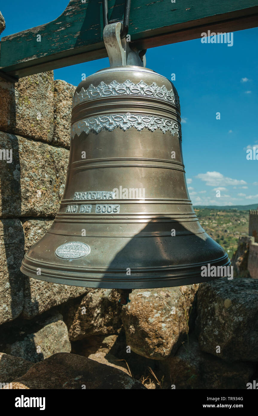 Bronze bells on top of thick stone brick wall, in a sunny day at ...