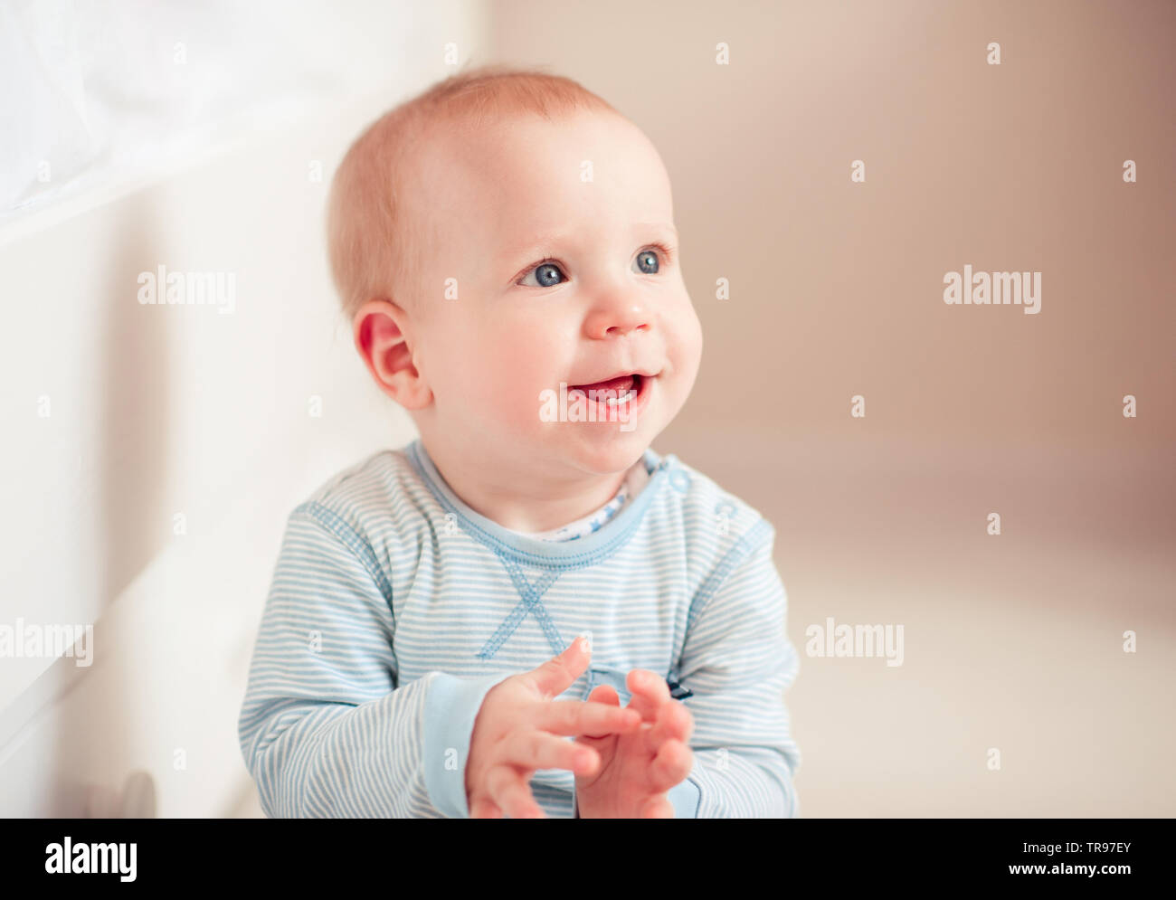 Cute baby boy sitting in room. Looking up. Childhood Stock Photo - Alamy