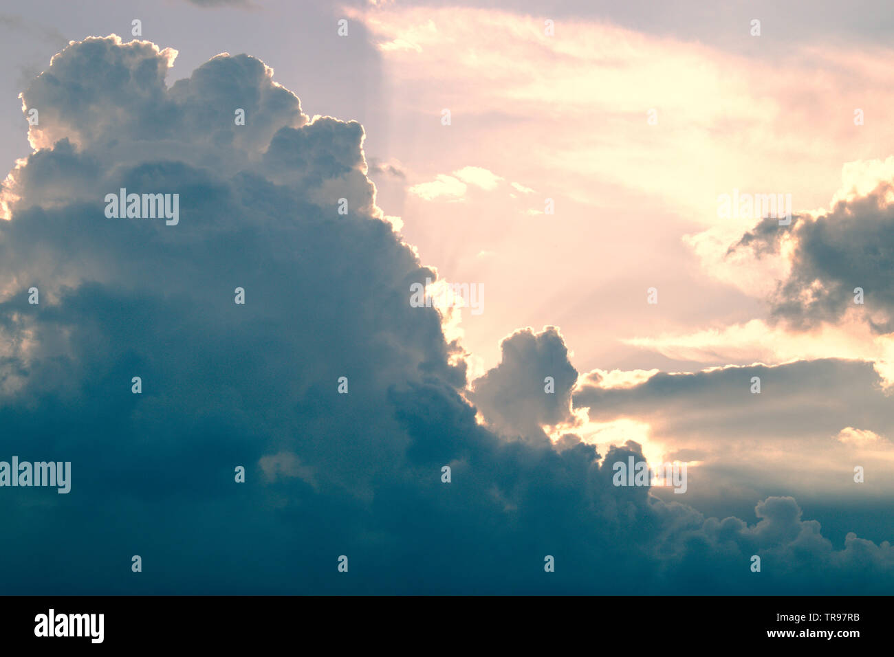 Sun rays breaking through dark clouds at sunset. Cumulus at sunset ...