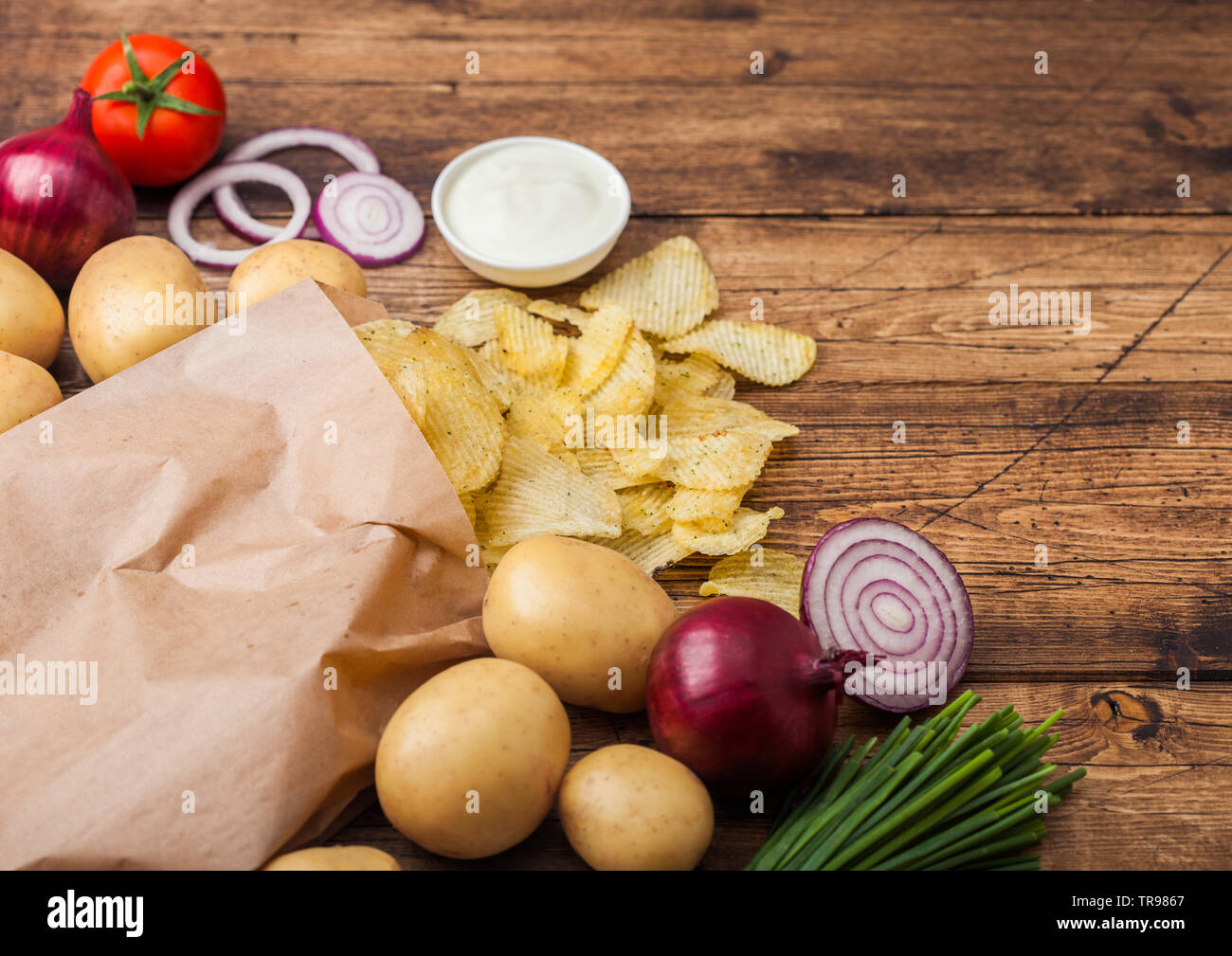 Fresh organic homemade potato crisps chips with sour cream and red ...