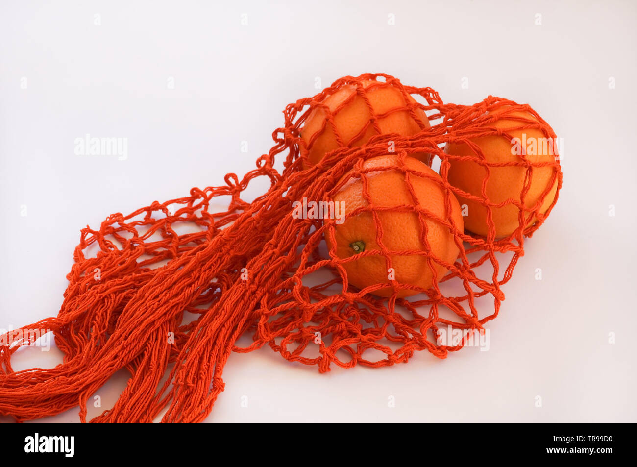 Handmade orange string bag with three oranges white background Stock ...