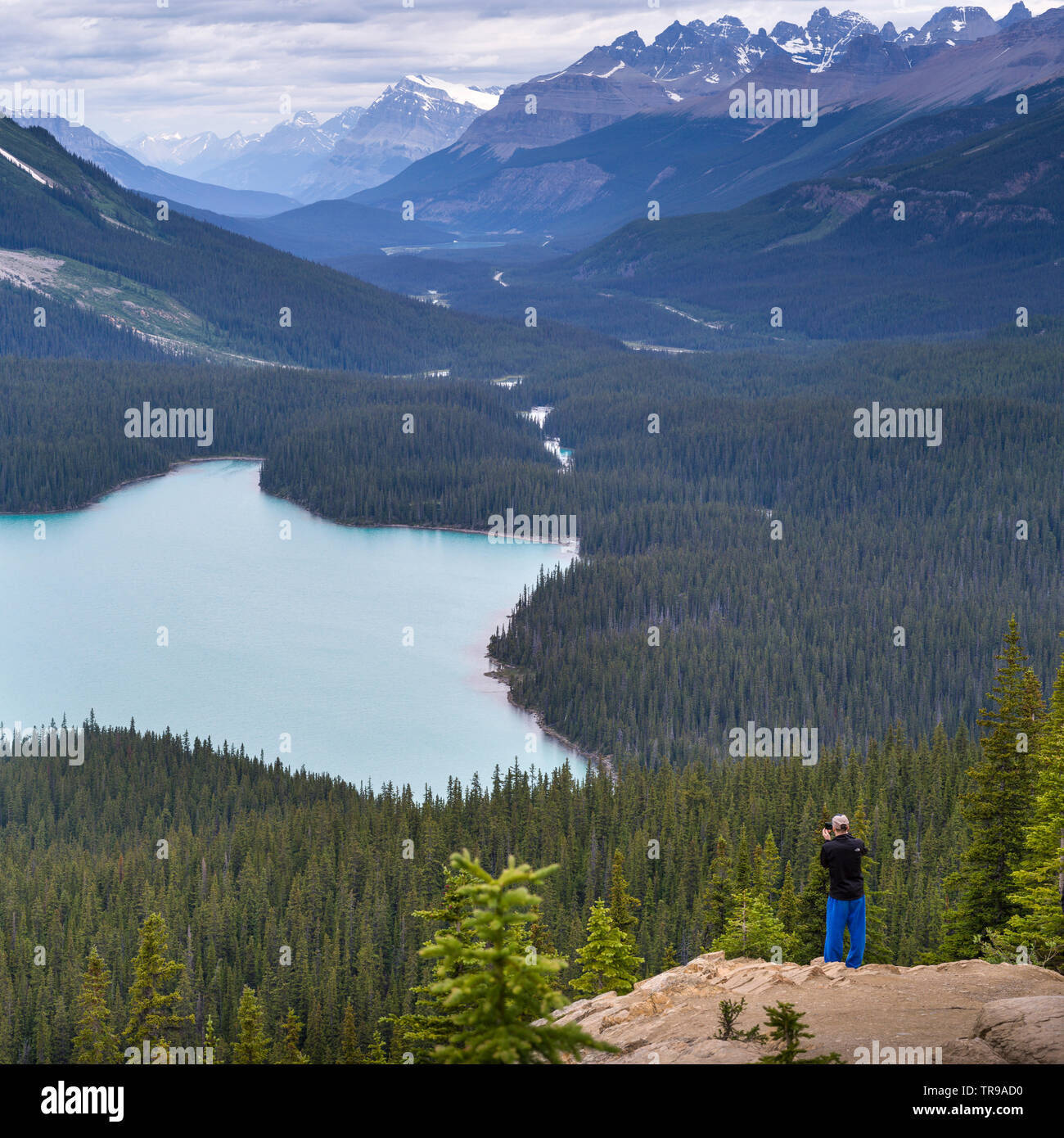 Man standing on cliff overlooking a lake Stock Photo - Alamy