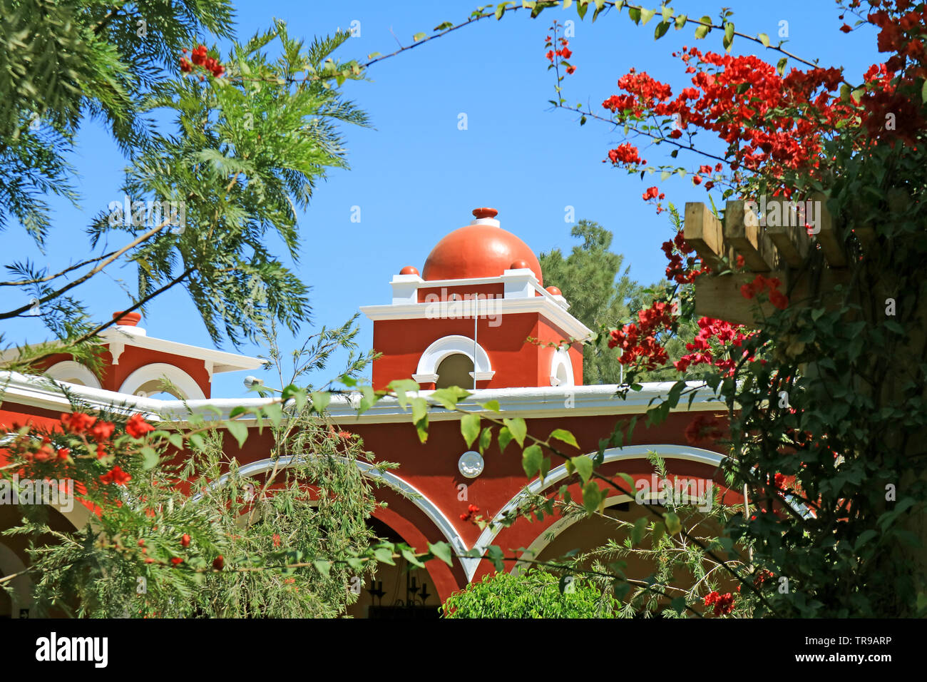 Vivid red and white dome of vintage Peruvian building against sunny ...