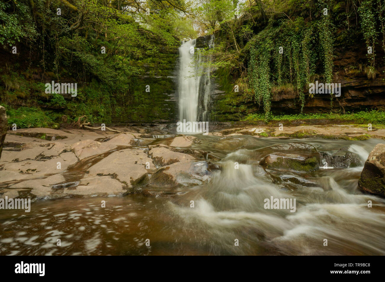A waterfall flowing into a river Stock Photo - Alamy