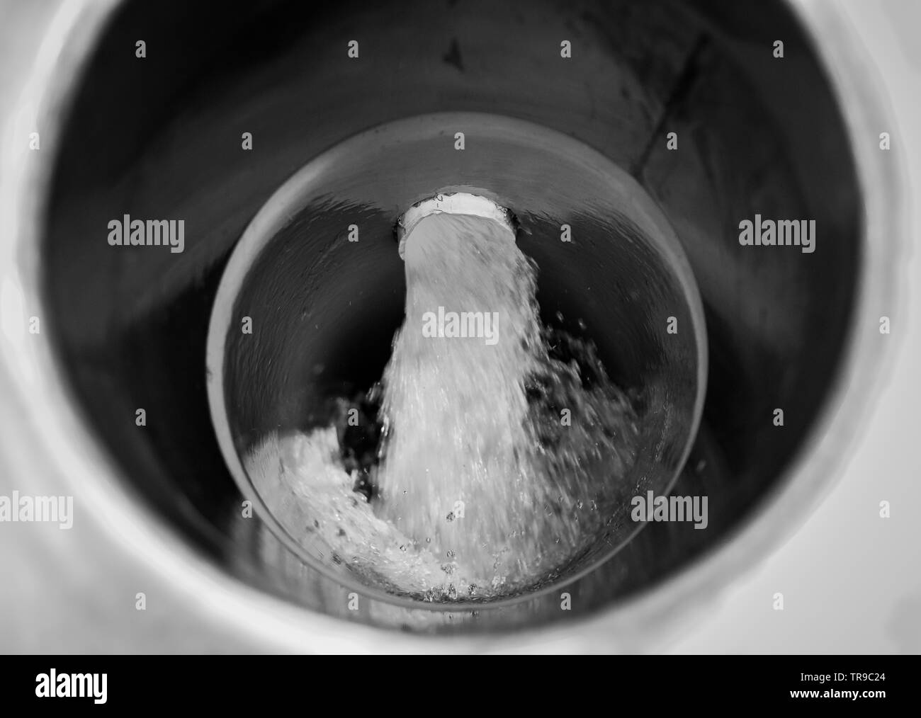 Water stream flows into a pipe for fish at a fish hatchery, viewed ...