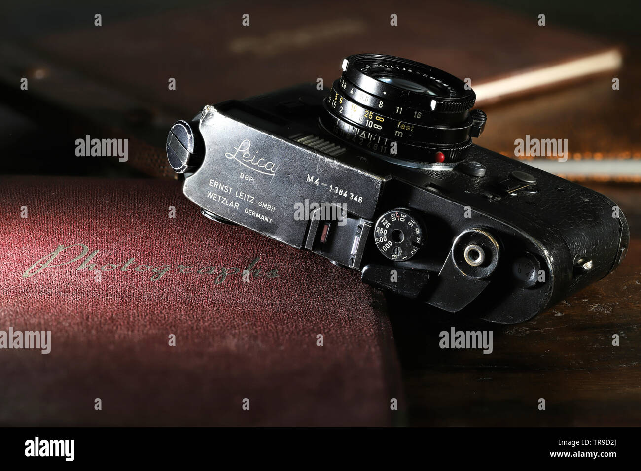 Heavy used Leica M4 camera with photo album on wooden table. The Leica ...