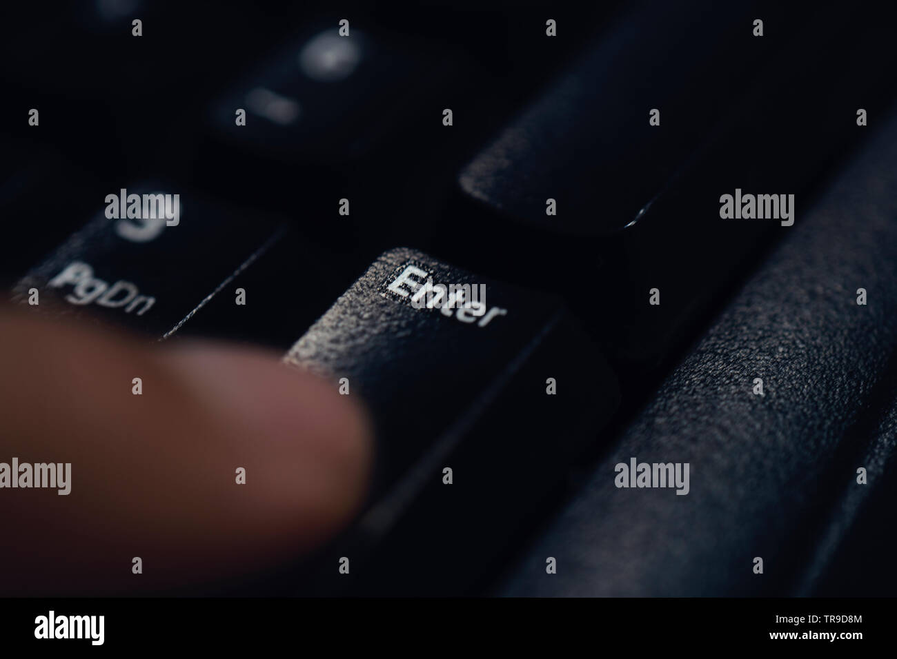 Finger pressing enter key close up Stock Photo - Alamy