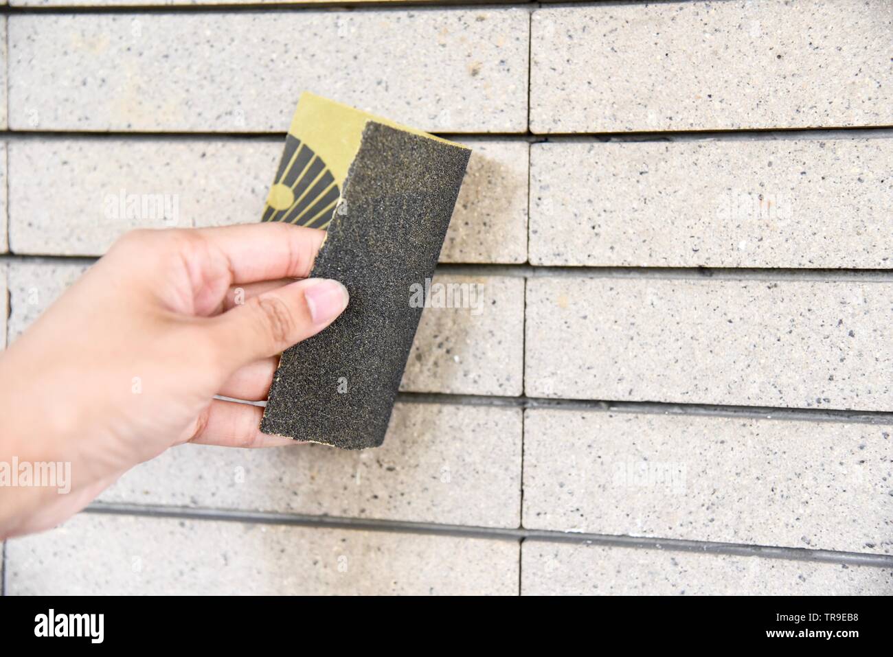 Hand Rubbing Wall with Sandpaper Stock Photo - Alamy