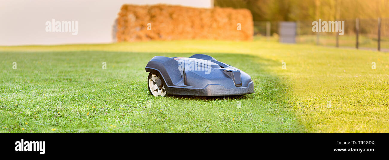 an automatic modern lawn mower panorama Stock Photo - Alamy