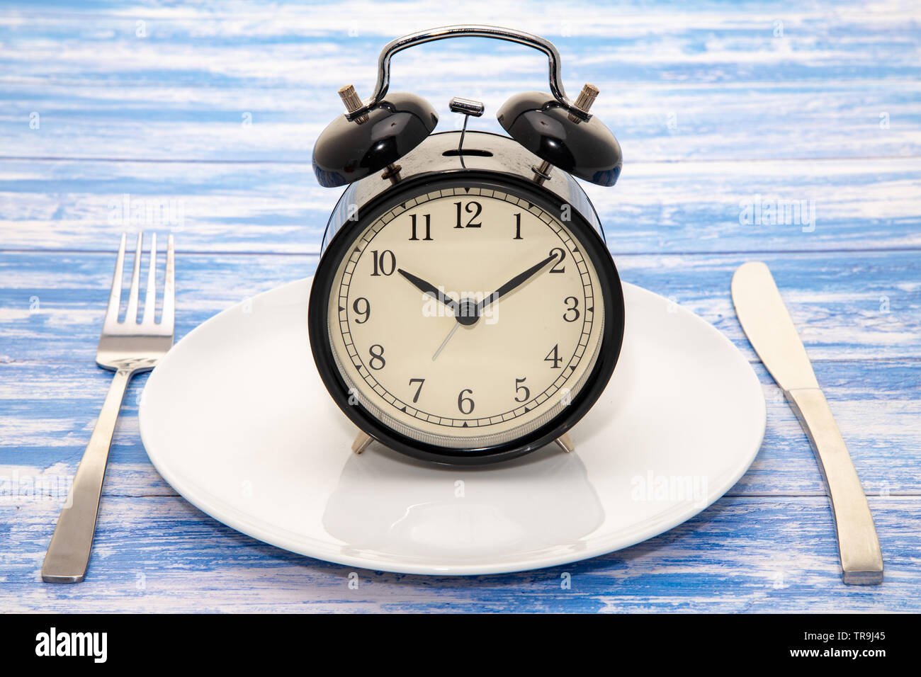 An alarm clock on a dinner plate - concept image Stock Photo - Alamy