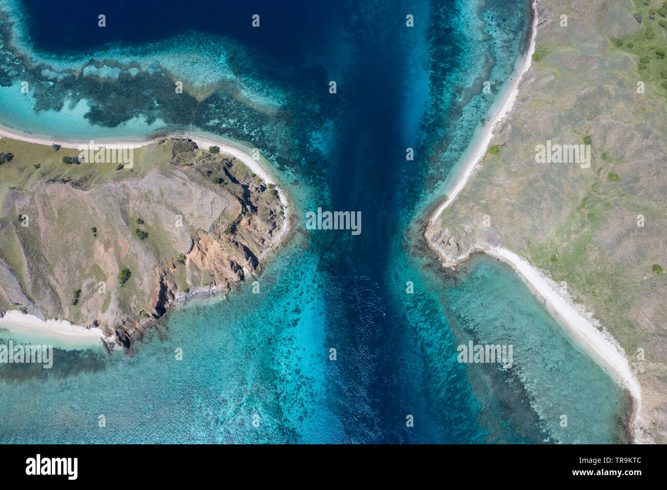 Seen from an aerial view, a narrow channel, fringed by coral reefs ...