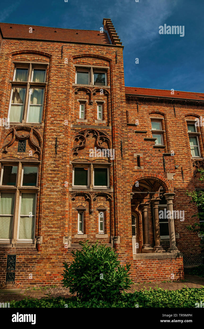 Brick facade of house in typical Flanders style and blue sky in Bruges ...