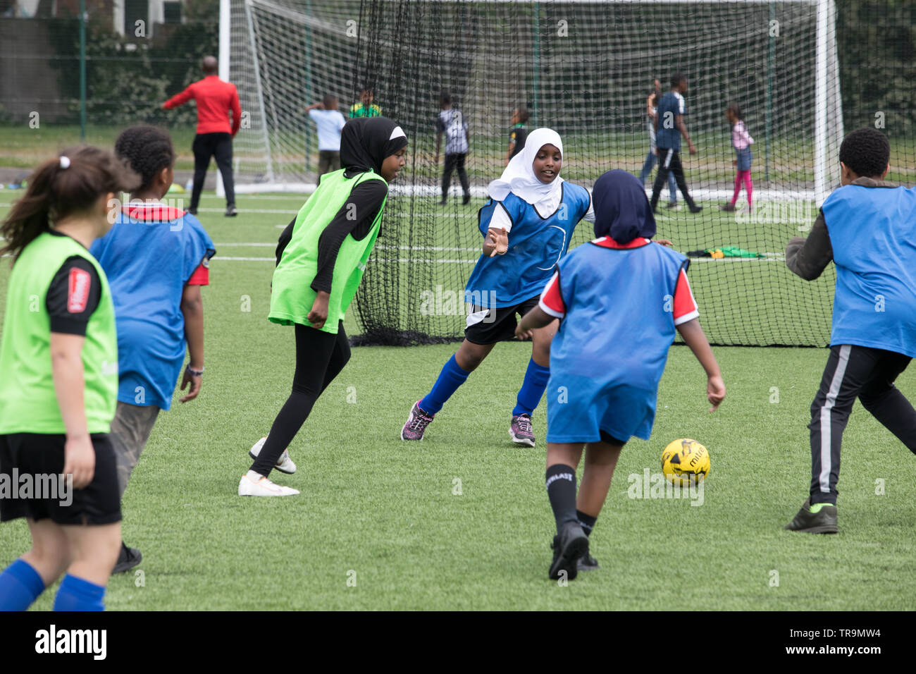 Muslim girls playing football on an astroturf training pitch. Some are ...