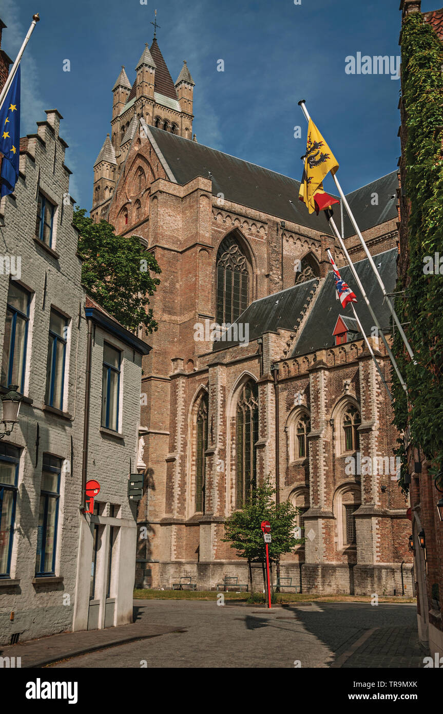 Cobblestone street with brick houses and church in Flanders style and ...