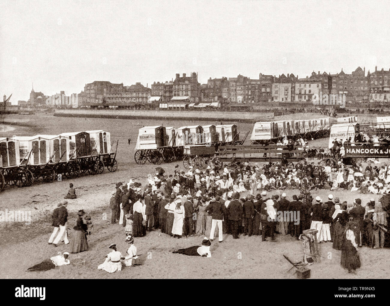 A 19th Century view of beach huts and crowd watching beach ...