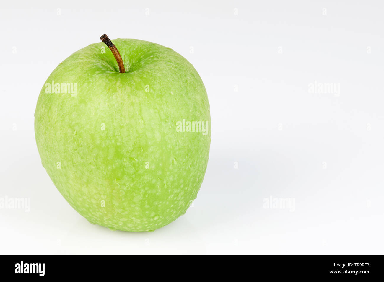 One green apple side view isolated on white background Stock Photo - Alamy