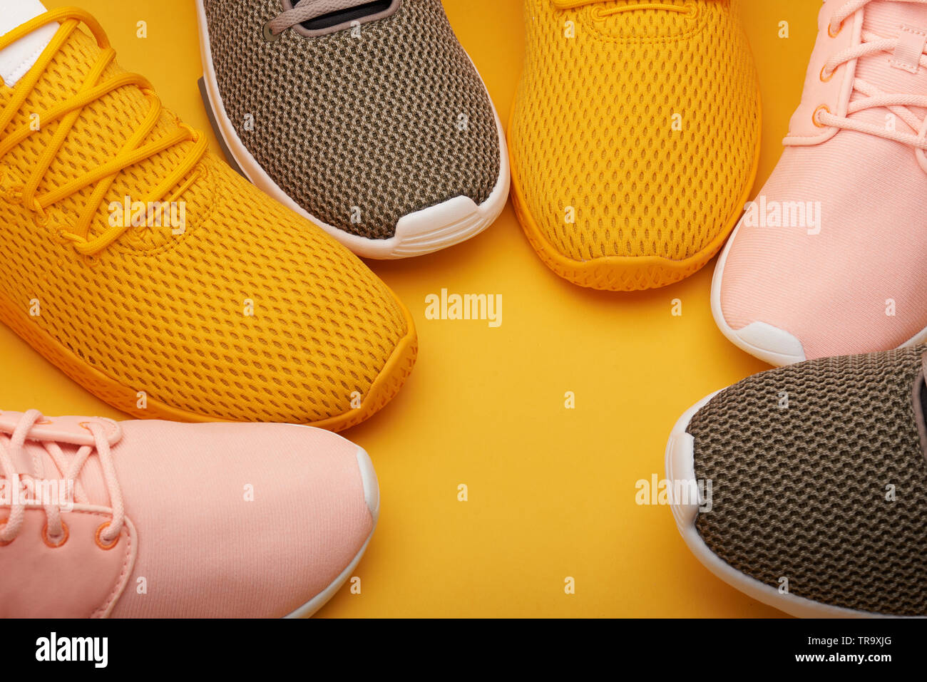 Stack of colorful sport shoes on yellow background Stock Photo - Alamy