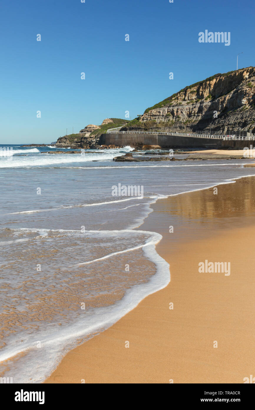 A wave rolls across the sand at the Southern end of Newcastle Beach ...
