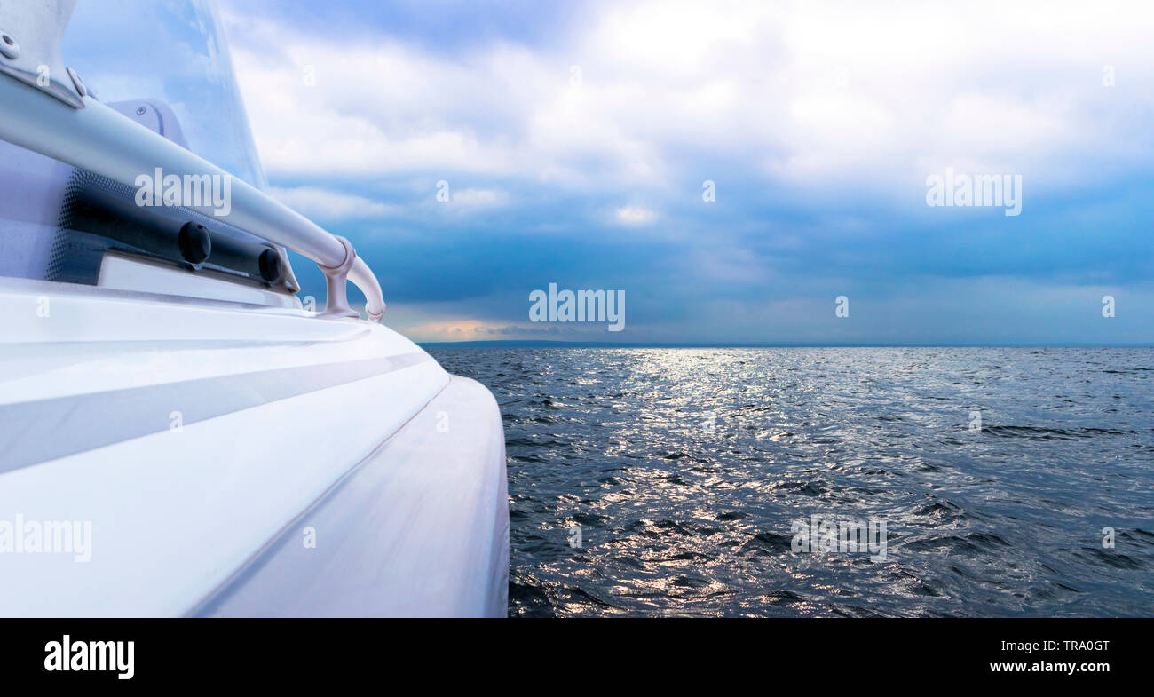 Side view Speeding fishing motor boat with drops of water. Blue ocean ...