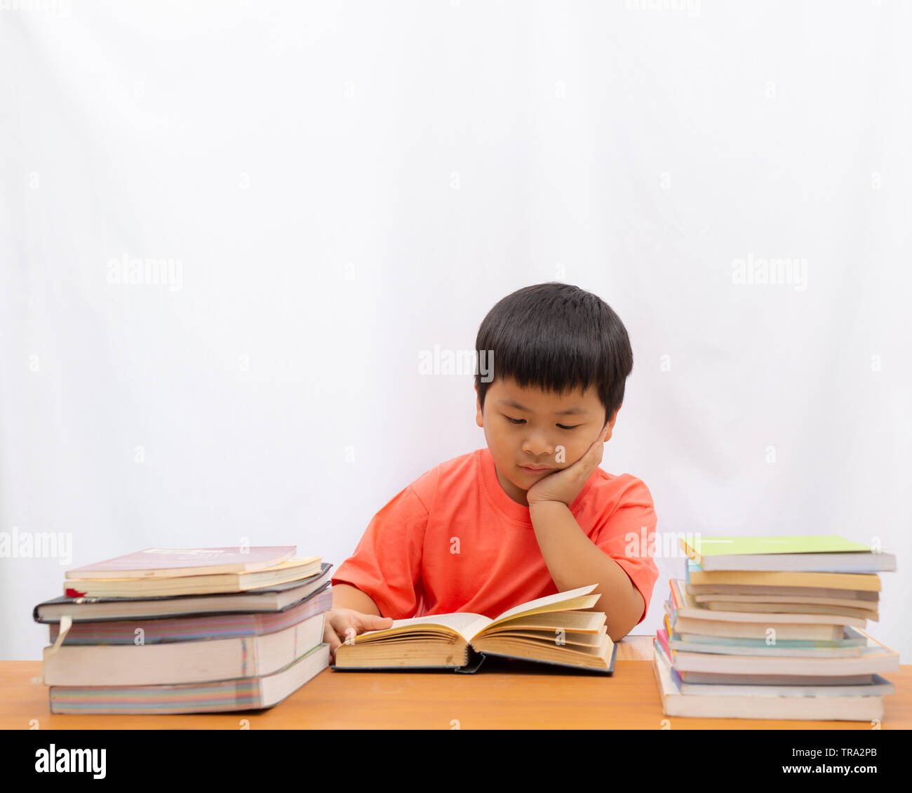 Cute a boy reading book on the table and white background Stock Photo ...