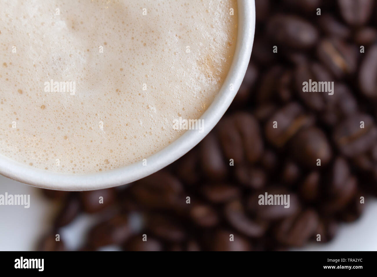 Hot coffee in paper cub on blurred raw seeds background, top view ...