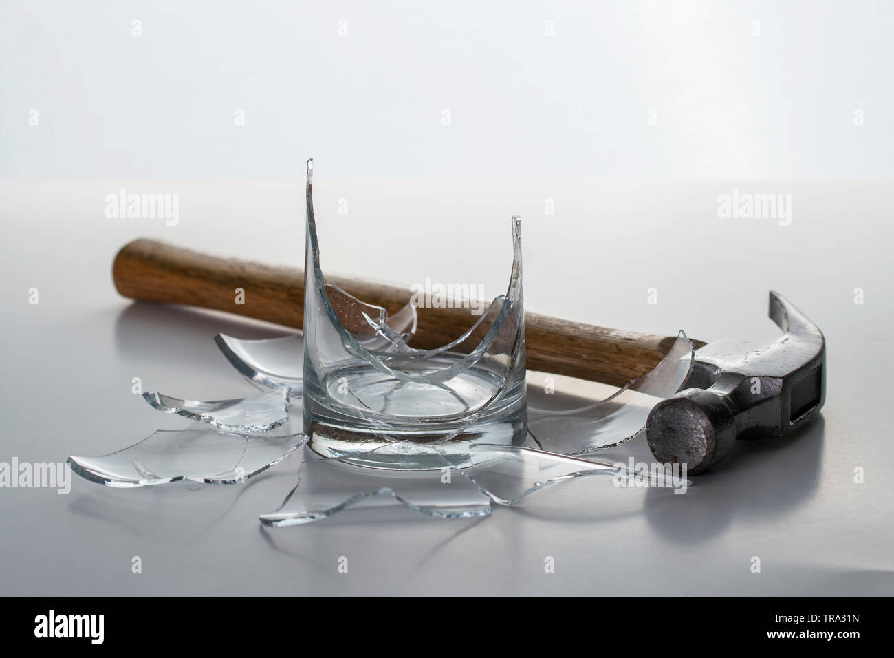 Broken Drinking Glass with hammer and shattered pieces on white ...