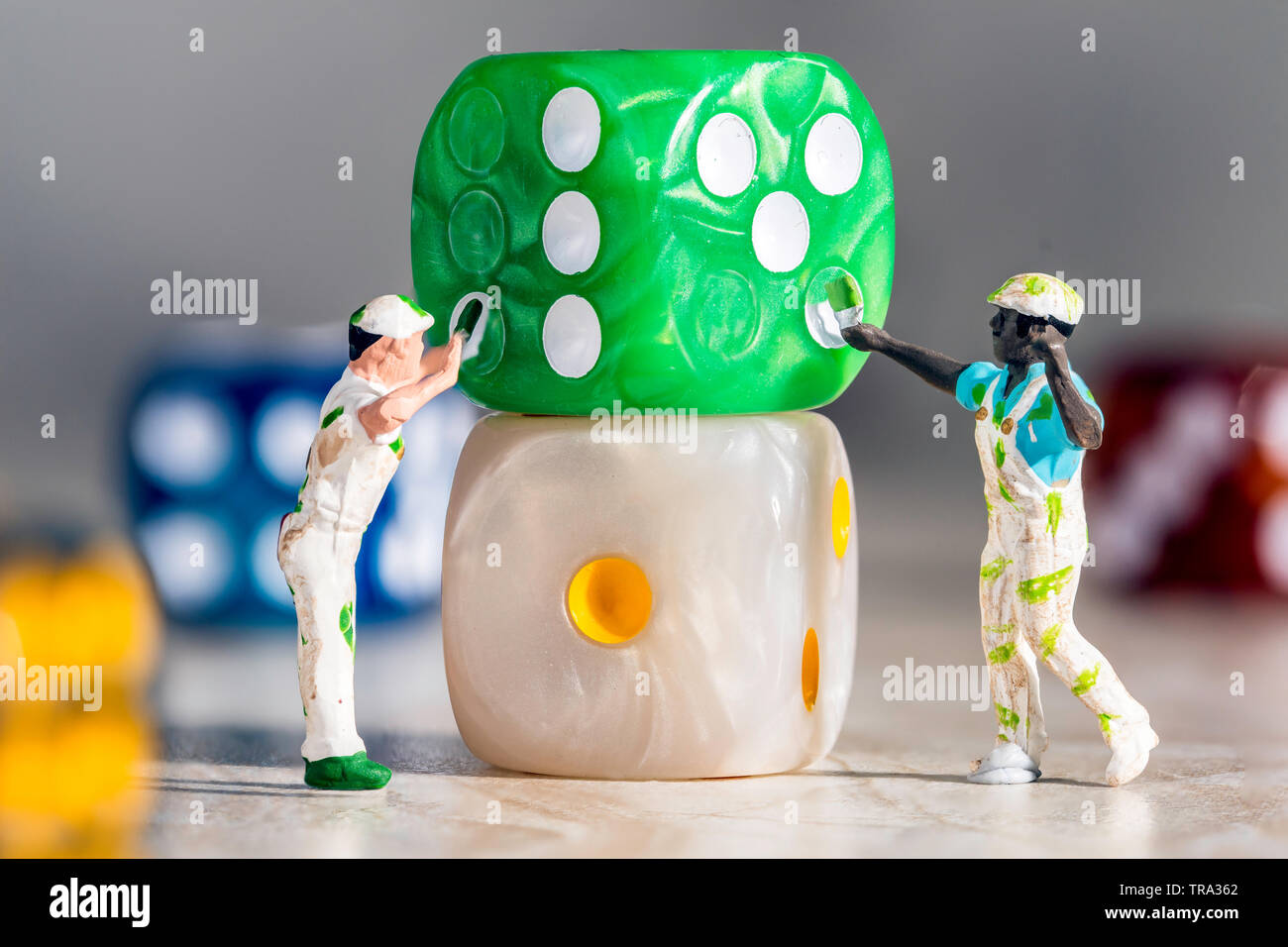 Two Miniature People Painters Painting green Dice with White Pips On a ...