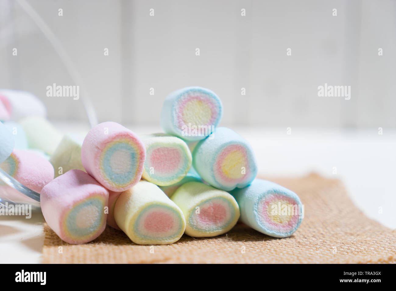 Color marshmallows on sack with white wooden background Stock Photo - Alamy