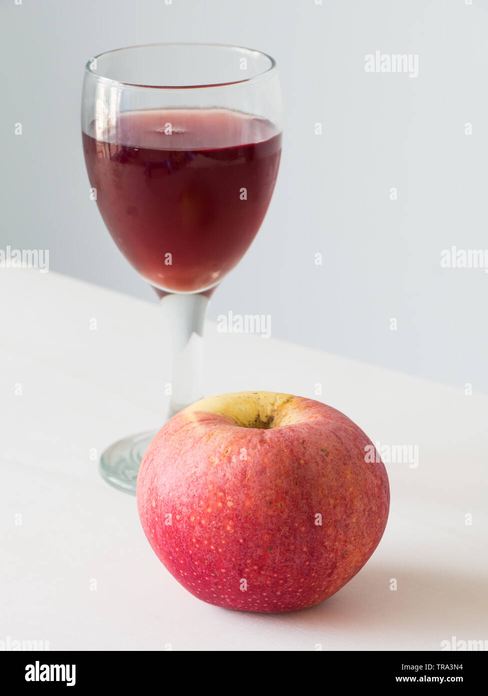 Red apple on wine in glass background Stock Photo - Alamy