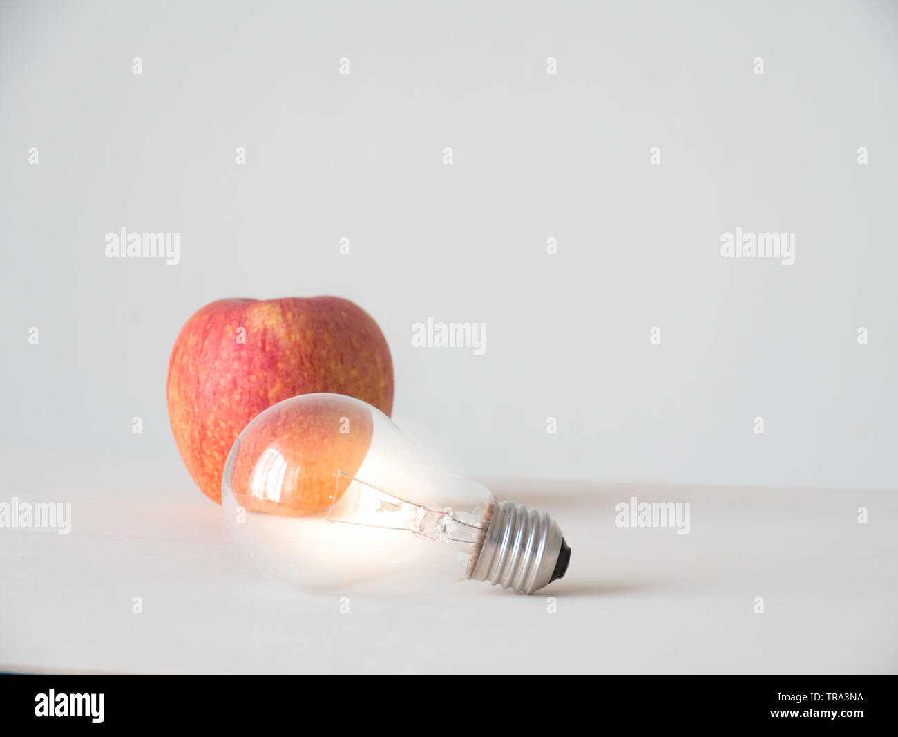 Light bulb in red apple on white background Stock Photo - Alamy