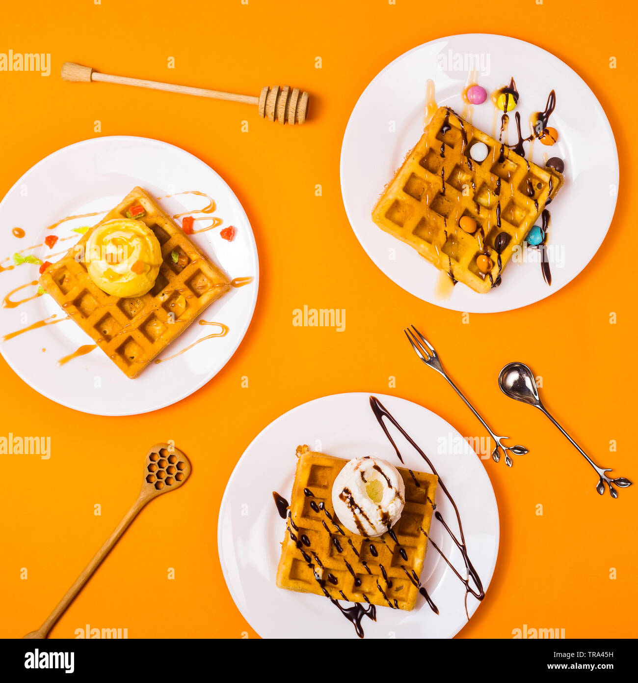 Fresh golden square Belgian waffles on plates with ice cream and ...